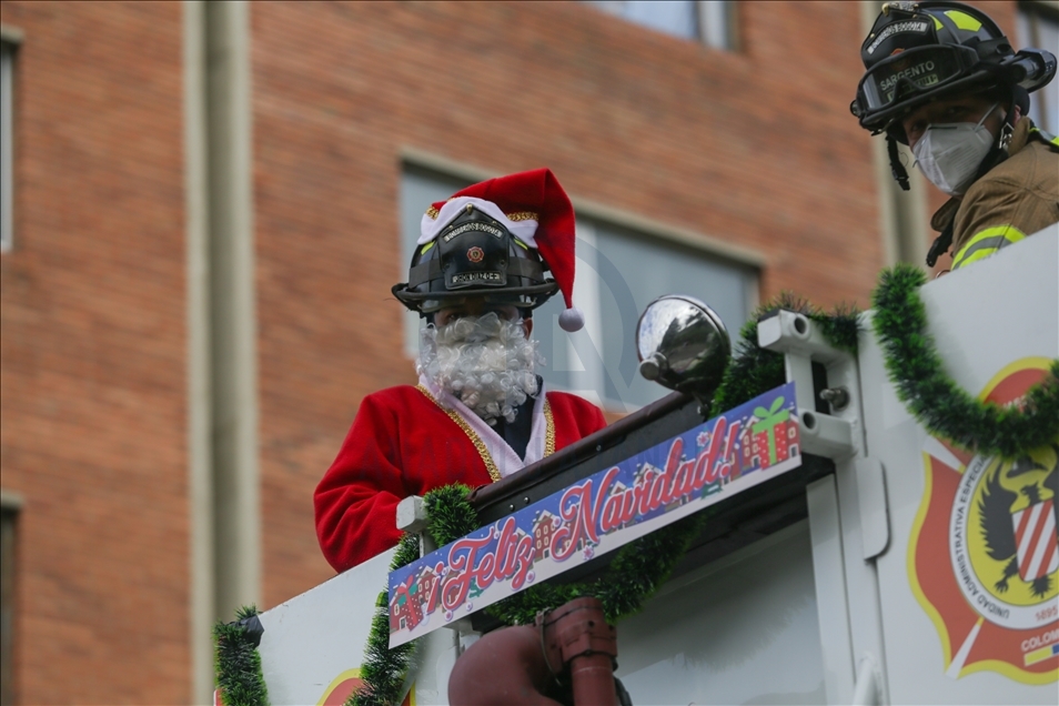 Firefighters dressed as Santa Claus deliver gifts to children at a ...